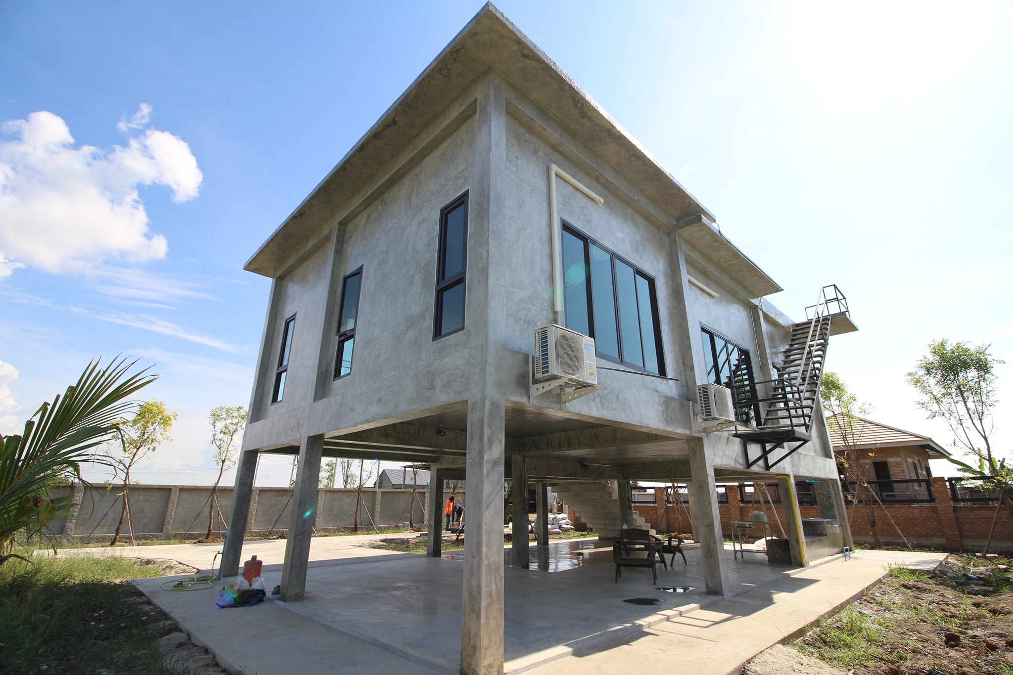 Concrete house on stilts with rural vibe