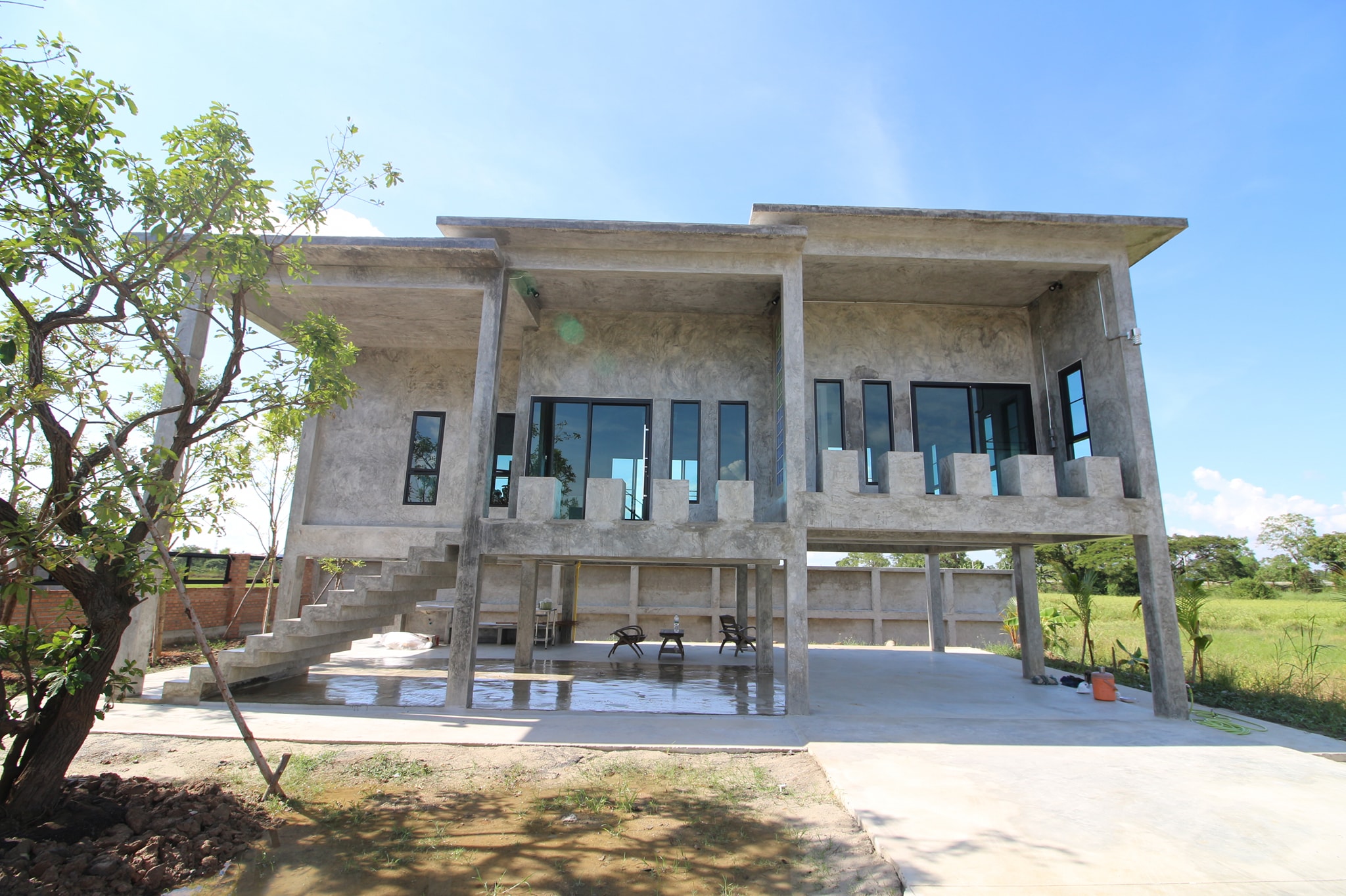 Concrete house on stilts with rural vibe