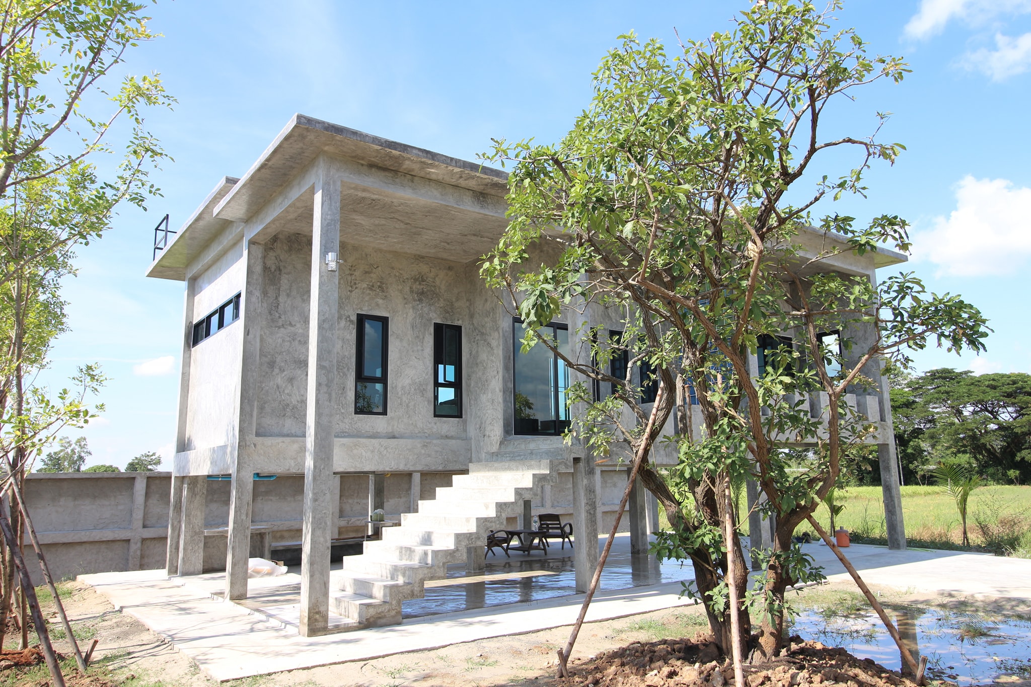 Concrete house on stilts with rural vibe